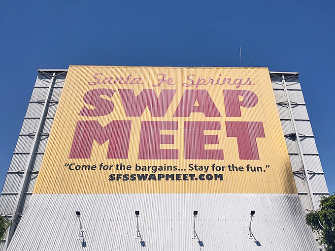 The Santa Fe Springs Swap Meet entrance beckons with a kaleidoscope of colorful blankets and character merchandise. Treasure hunting begins here!