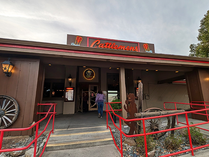 Red railings guide hungry patrons to the promised land of prime beef. That cowboy silhouette isn't just decoration&mdash;it's foreshadowing.