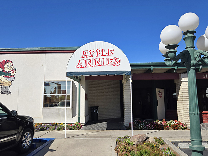 The iconic white awning of Apple Annie's welcomes hungry travelers like a culinary lighthouse in Tulare's sea of agriculture. Those vintage street lamps aren't just for show.