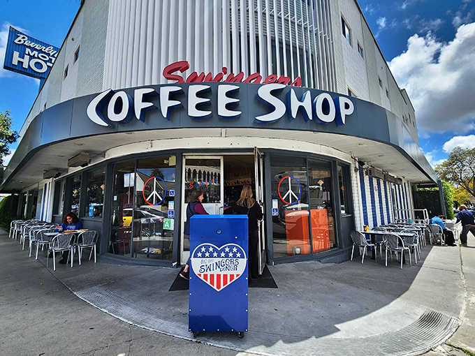 The iconic curved exterior of Swingers Diner stands like a mid-century time capsule on Beverly Boulevard, palm trees swaying in approval.