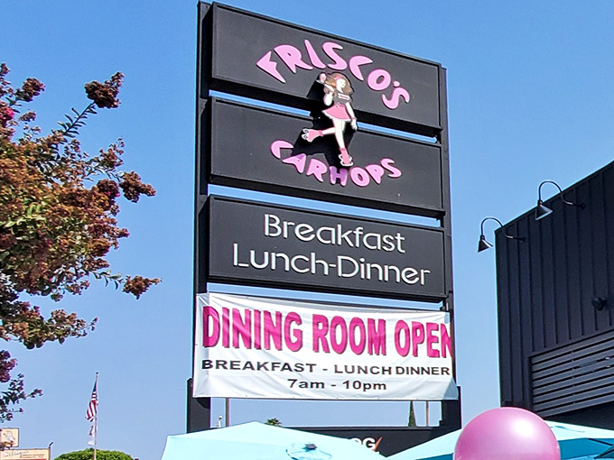 The pink and blue signage of Frisco's stands tall against the California sky, promising retro delights with modern flair. A balloon adds a touch of whimsy.