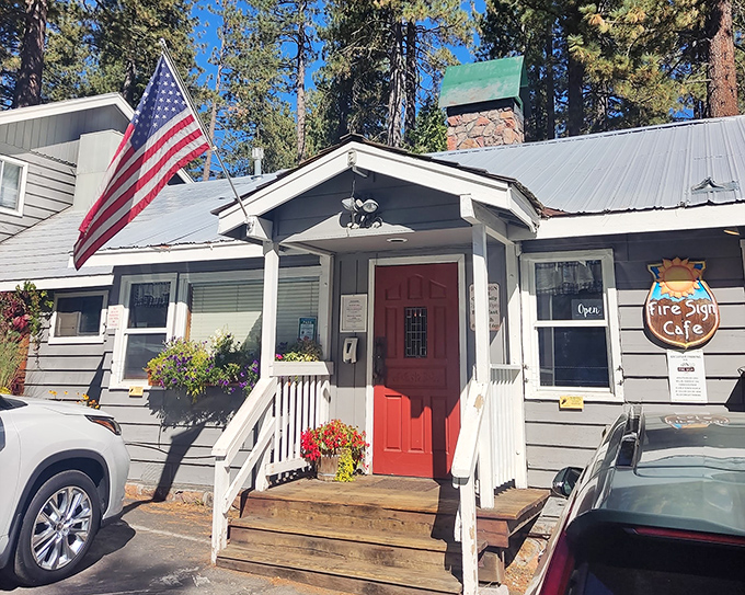 The quintessential Tahoe hideaway &ndash; a blue cabin nestled among pines, complete with white porch and American flag. Breakfast paradise awaits!