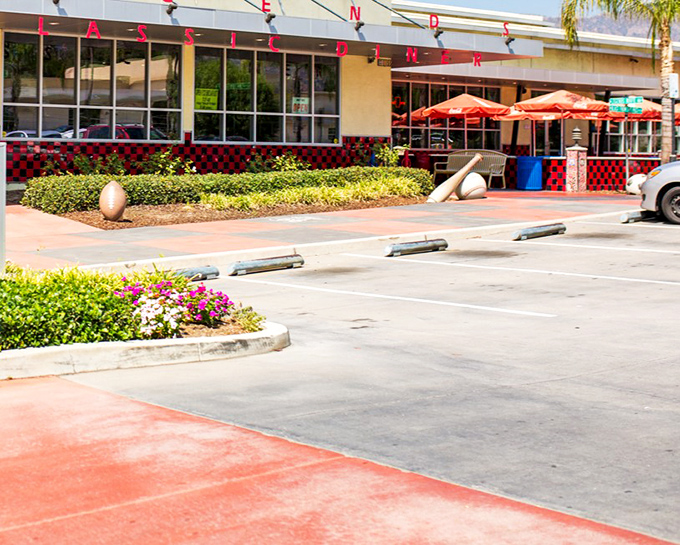 The classic exterior of Legends beckons with its vibrant landscaping and inviting red umbrellas&mdash;a time capsule of Americana waiting in Glendora.
