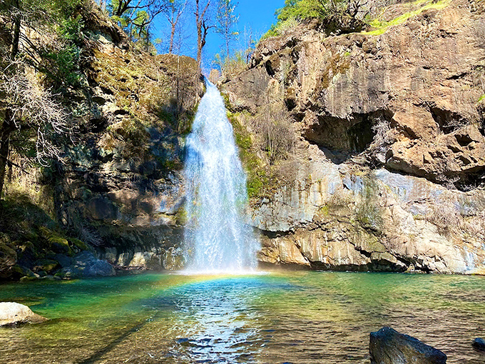 Nature's perfect curtain call: Potem Falls plunges 70 feet into an emerald pool, framed by maple leaves like nature's own theater curtains.
