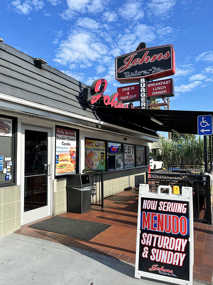 The iconic red neon sign of John's Drive-In beckons hungry travelers like a lighthouse for the famished. No fancy frills, just the promise of honest-to-goodness burgers.