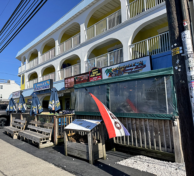 The iconic yellow-accented exterior of Woody's stands like a beacon of seafood salvation on Coastal Highway, promising crab-filled dreams and beach memories.