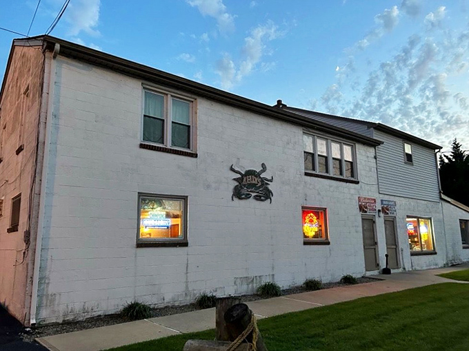 The unassuming white exterior of Kelly's Tavern in Port Penn might fool you, but that crab sign? That's nature's way of saying "treasure inside."