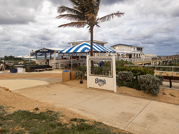 Benny's white beach shack exterior with blue awnings isn't trying to impress you—until you taste what's inside and realize you've found Florida's seafood mothership.