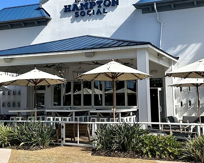 The Hampton Social's pristine white exterior with blue accents isn't just a building&mdash;it's a promise of coastal elegance waiting just beyond those doors.