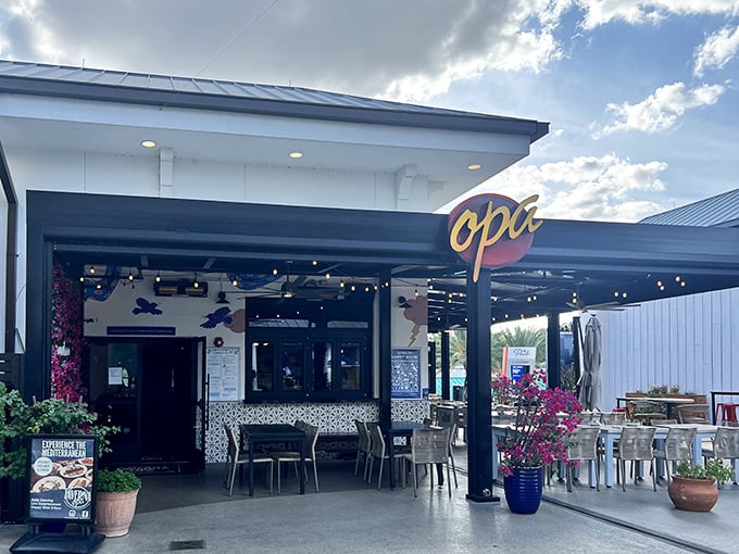 The inviting exterior of Taverna Opa beckons with its crisp white walls and signature blue accents, promising Mediterranean delights just steps away from Orlando's tourist hustle.