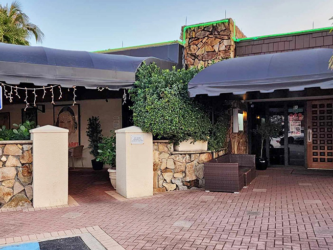 Stone walls and brick pathways whisper promises of the carnivorous adventures waiting inside this steakhouse sanctuary.