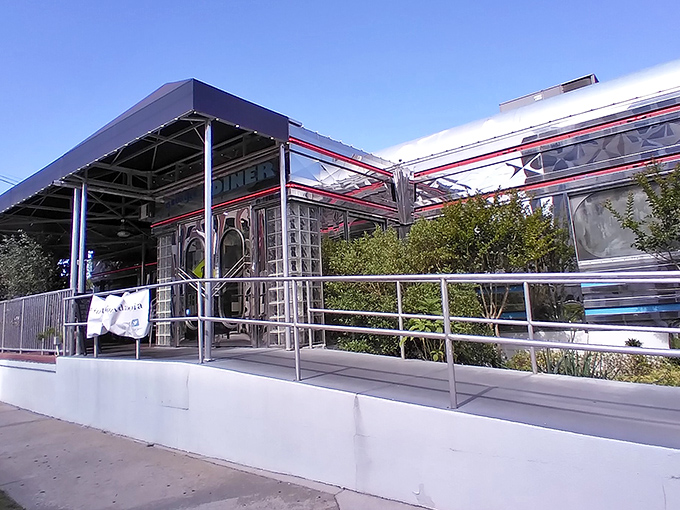 The gleaming stainless steel exterior of Georgie's Diner catches Florida sunshine like a time machine from the 1950s, complete with classic red trim and glass block windows.