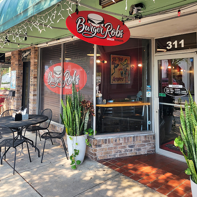 A closer look at BurgerRobs' inviting entrance, where tall potted plants frame the doorway like sentinels guarding the temple of burger artistry.