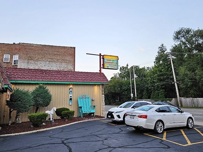 Don't judge this tiki paradise by its humble exterior. That blue Adirondack chair is basically saying, "Slow down, friend, culinary magic happens inside."