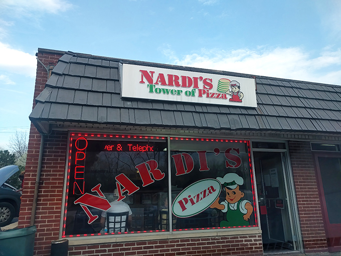 The unassuming storefront that houses pizza greatness. Blue shingled roof, red brick, and Italian flag colors promise authentic flavors inside.
