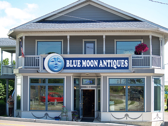 The iconic Blue Moon Antiques facade welcomes treasure hunters with its distinctive lunar logo and inviting wraparound porch&mdash;architectural eye candy for antiquing enthusiasts.