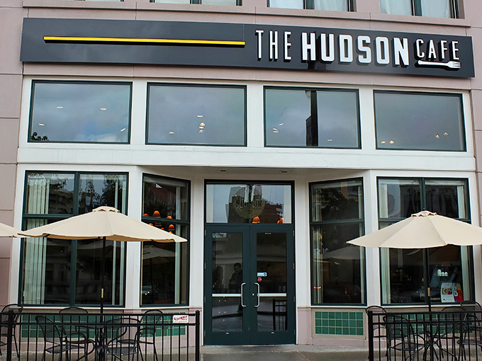 The sleek exterior of The Hudson Cafe stands as a modern beacon for breakfast enthusiasts on Woodward Avenue, complete with inviting patio seating.