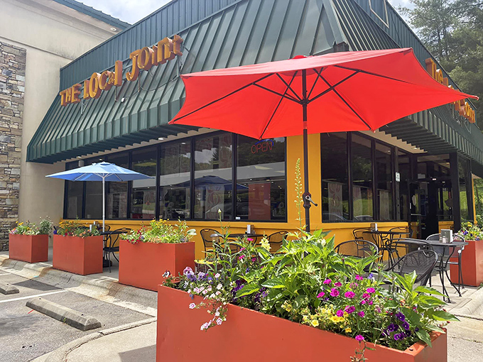 The Local Joint's cheerful exterior with vibrant planters and colorful umbrellas promises the kind of breakfast experience worth setting your alarm for.