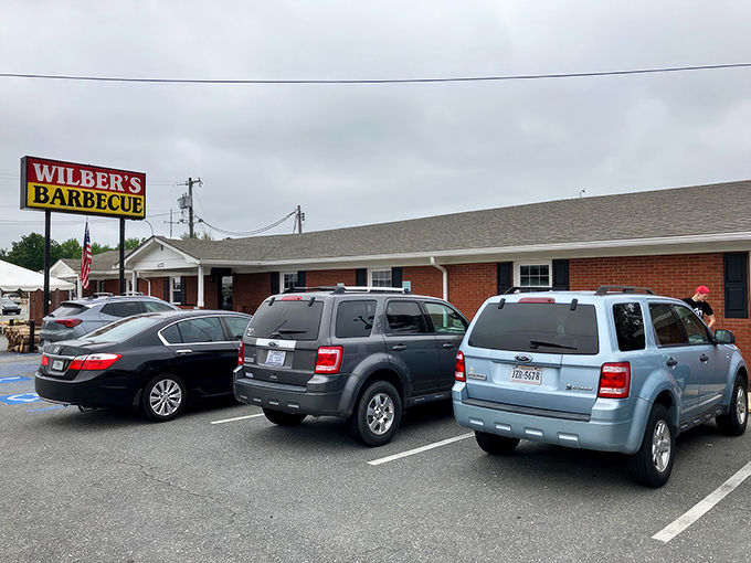 The iconic red and yellow sign beckons hungry travelers like a barbecue lighthouse on Highway 70. Simple brick exterior, extraordinary flavors within.