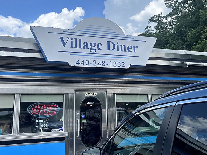 The classic silver exterior of Village Diner gleams in the Ohio sunshine, promising breakfast dreams come true behind those unassuming doors.