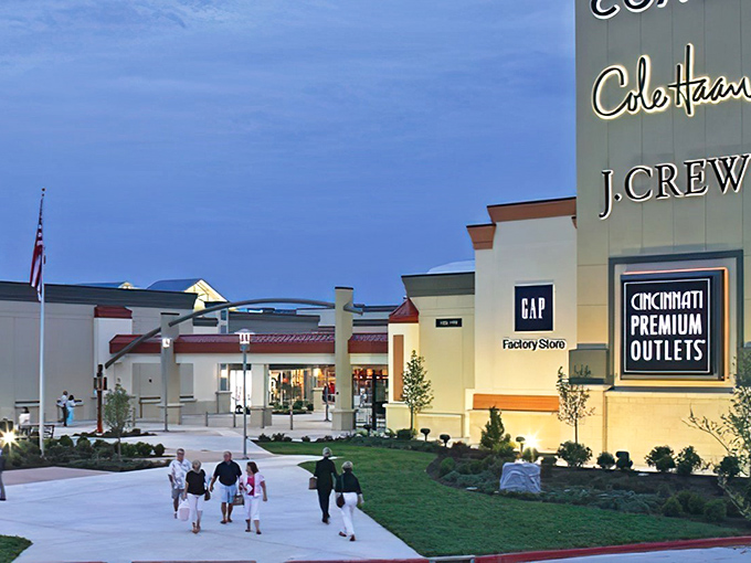 The retail promised land beckons at dusk, where Cincinnati Premium Outlets transforms shopping from chore to adventure. Those glowing storefronts practically whisper "bargains inside!"
