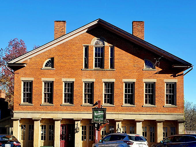 The historic brick façade of The Warehouse Restaurant stands proudly in Coshocton, its burgundy doors promising culinary adventures within those sturdy walls.
