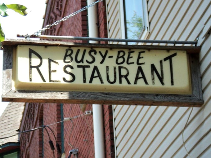 The vintage sign hanging outside Busy Bee Restaurant has that perfect weathered charm that promises authentic food rather than Instagram bait.