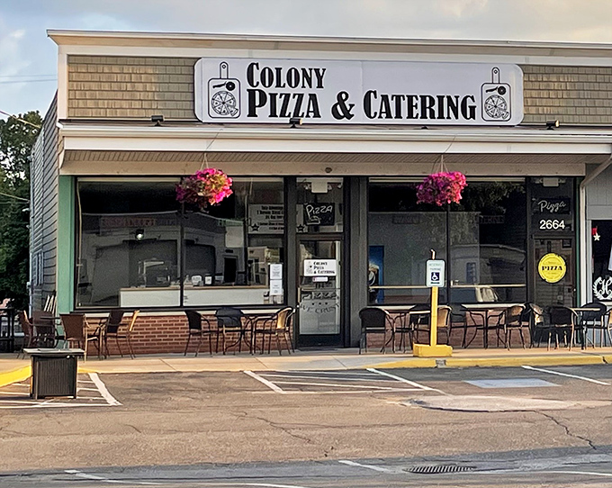 The unassuming storefront of Colony Pizza, where hanging flower baskets add a touch of charm to this Erie culinary treasure hiding in plain sight.