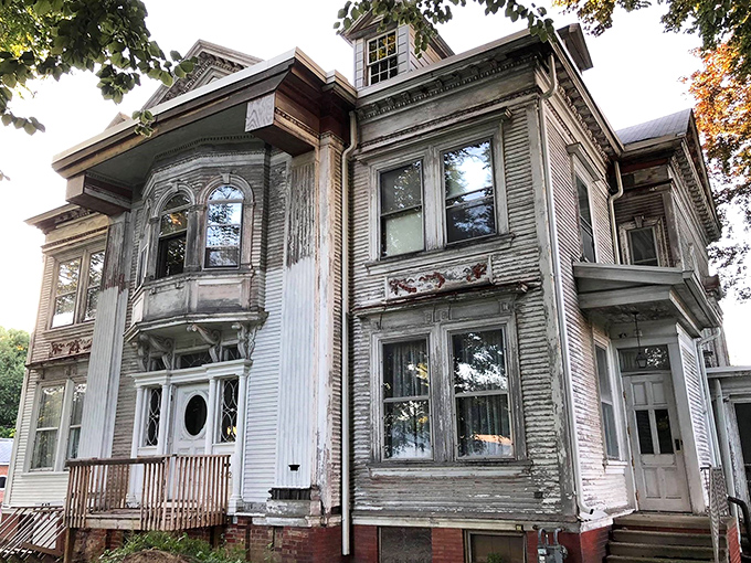 The weathered grandeur of the Gill House stands as a Victorian time capsule, its bay windows and ornate details whispering stories of a bygone era.