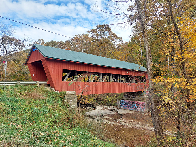 The classic red siding against autumn foliage creates nature's perfect color palette. This isn't just a bridge&mdash;it's a portal to simpler times.
