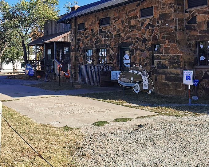 The rugged stone exterior of Rock Cafe stands as a Route 66 sentinel, with its vintage charm and Sheriff car cutout welcoming hungry travelers since 1939.