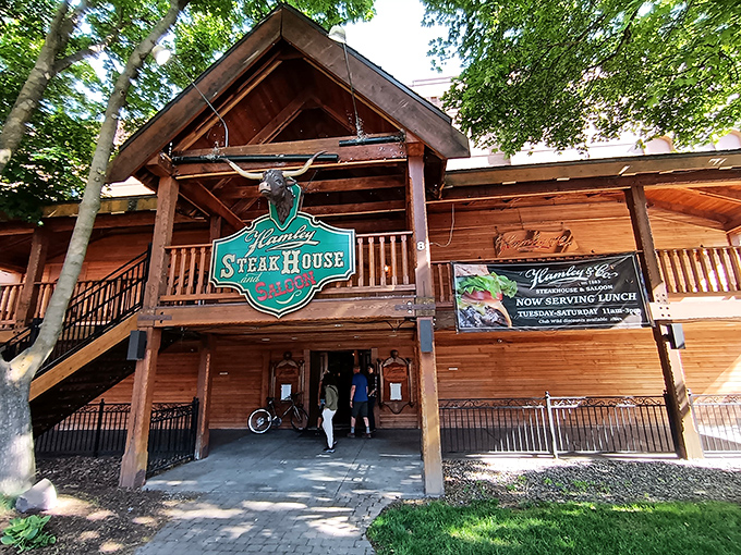 The rustic wooden facade of Hamley Steakhouse beckons like a time portal to the Wild West, complete with that iconic green sign promising carnivorous delights.