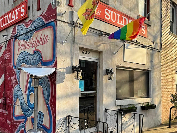The unassuming facade of Sulimay's welcomes you with its vintage sign and rainbow flag, promising both tradition and inclusivity in Philadelphia's evolving Fishtown neighborhood.