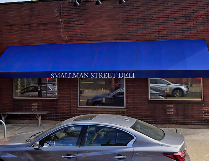 The bright blue awning against red brick is like a culinary bat signal for sandwich lovers across Pittsburgh's Strip District.
