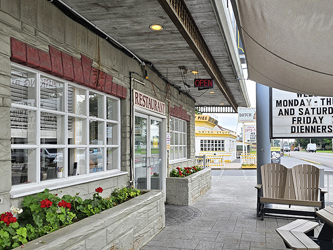 Red geraniums welcome you to the porch, where Adirondack chairs invite a moment of contemplation before the feast begins.