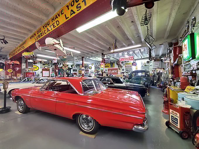 A classic car gleams under vintage signs asking "When did you lubricate last?" The answer: whenever Detroit still made them this beautiful.