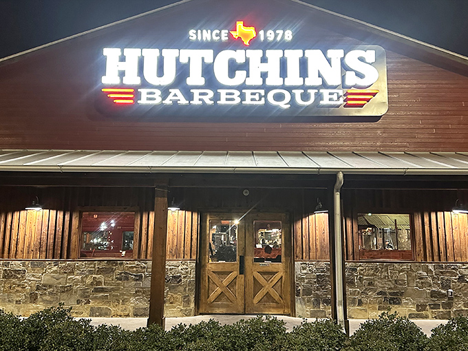 The neon glow of Hutchins BBQ beckons like a lighthouse for the hungry, promising smoky salvation since 1978.