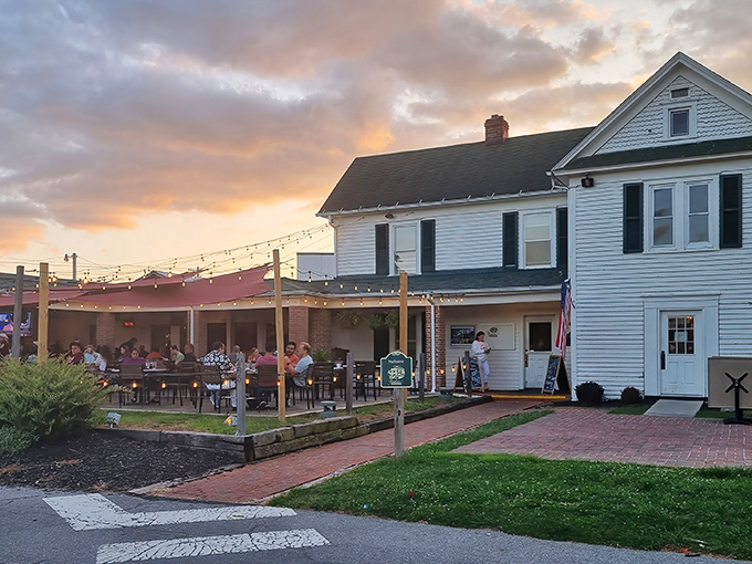 The Farmhouse welcomes you with classic white clapboard charm and a patio where string lights twinkle like stars over your evening feast.