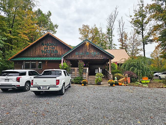 The rustic cabin exterior of Smoke on the Water beckons like a siren song to BBQ lovers. Fall decorations add seasonal charm to this woodland barbecue haven.