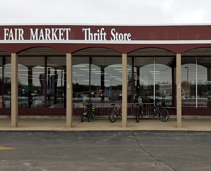 The unassuming storefront of Fair Market Thrift Store beckons with the promise of hidden treasures behind those large windows. Bicycles parked outside hint at local loyalty.