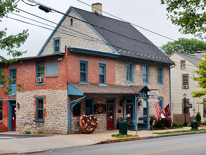 That bright blue porch practically announces "pretzel paradise ahead!" while the giant pretzel sculpture stands guard like a carb-laden sentinel welcoming hungry visitors.