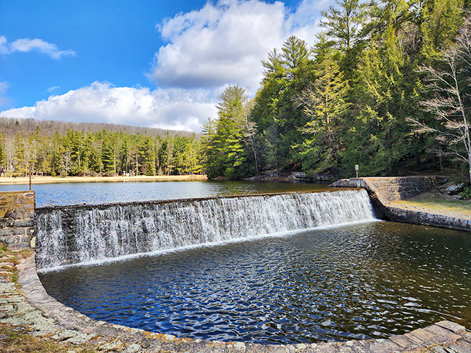Nature's perfect mirror: the lake at Raymond B. Winter State Park reflects towering pines and puffy clouds like Mother Nature's own Instagram filter.