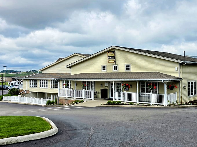 The welcoming yellow exterior of Dutch Valley Restaurant stands like a beacon of comfort food in Sugarcreek's rolling countryside. Those hanging flower baskets aren't just for show!
