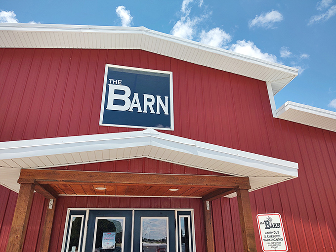 The iconic red exterior of The Barn stands proudly against a blue Kansas sky, like a beacon calling hungry travelers home.