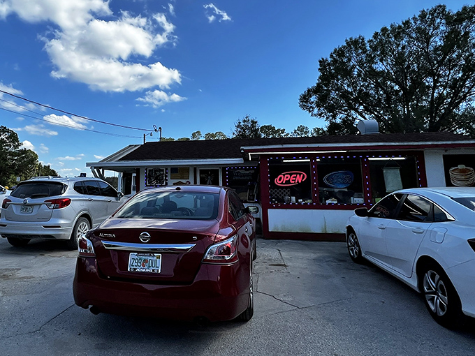 The unassuming exterior of Red Top Pit Stop beckons with its neon "OPEN" sign&mdash;a humble invitation to one of Florida's most delicious BBQ experiences.