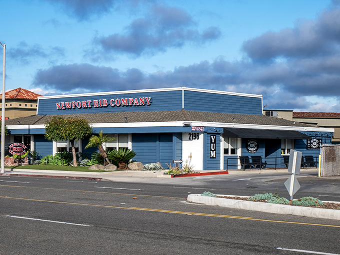 The unassuming blue exterior of Newport Rib Company hides a barbecue paradise within. That "YUM" sign isn't just decoration&mdash;it's truth in advertising.