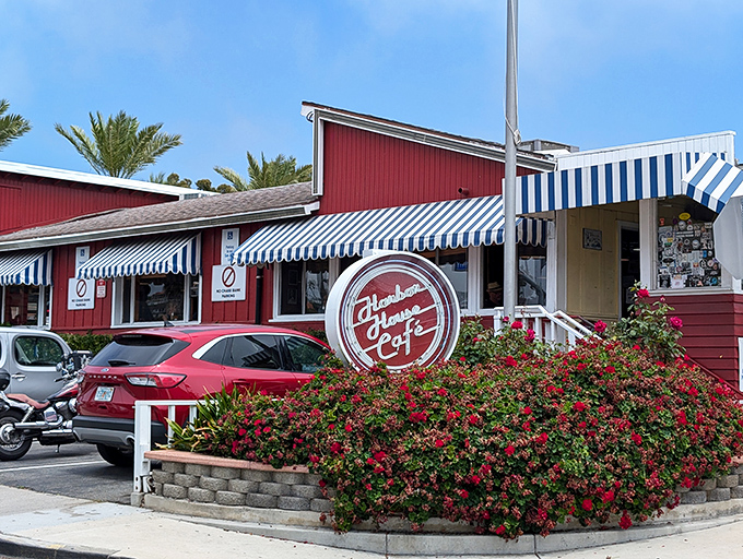 The iconic red exterior with blue-and-white awnings isn't just eye-catching—it's a time portal to when diners ruled American roadways.