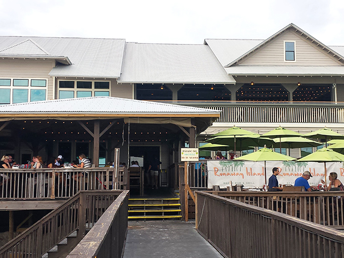 Runaway Island's inviting entrance beckons seafood lovers through wooden boardwalks to beachfront dining paradise where grouper sandwich legends are born.