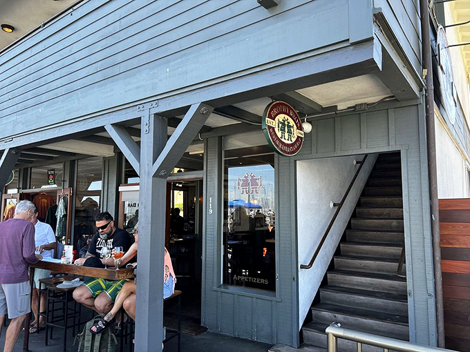 The no-frills exterior waves a hearty welcome at Brophy Bros., where that iconic circular sign promises seafood treasures within those weathered blue-gray walls.