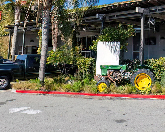 A vintage tractor adds unexpected charm to the landscaping. California casual meets farmhouse aesthetic in this delightful exterior touch.